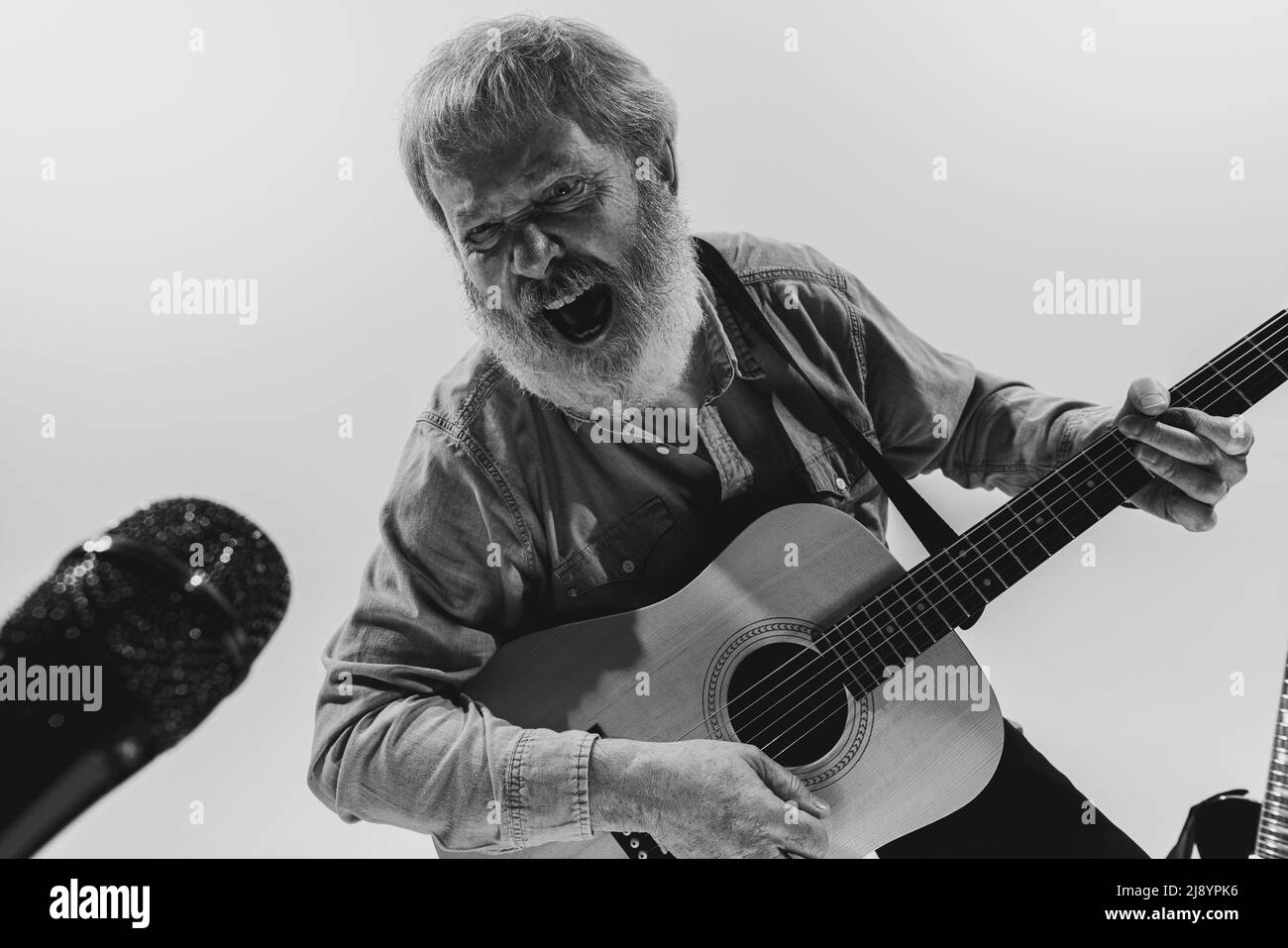 Black and white portrait of stylish old man, rock musician playing ...