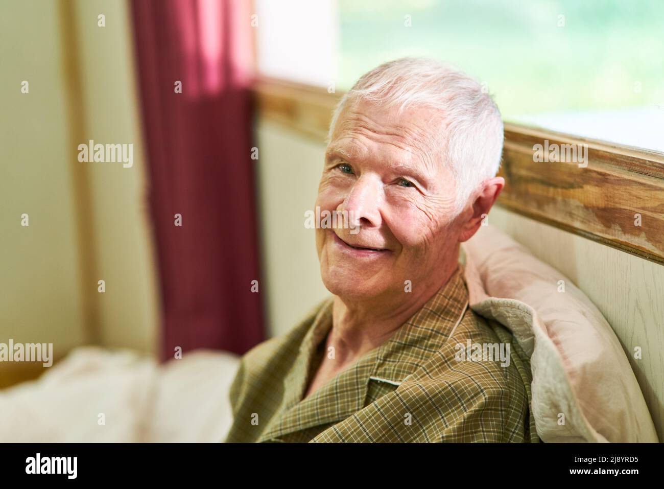 Sick old man in pajamas lies in bed in nursing home or hospital Stock ...