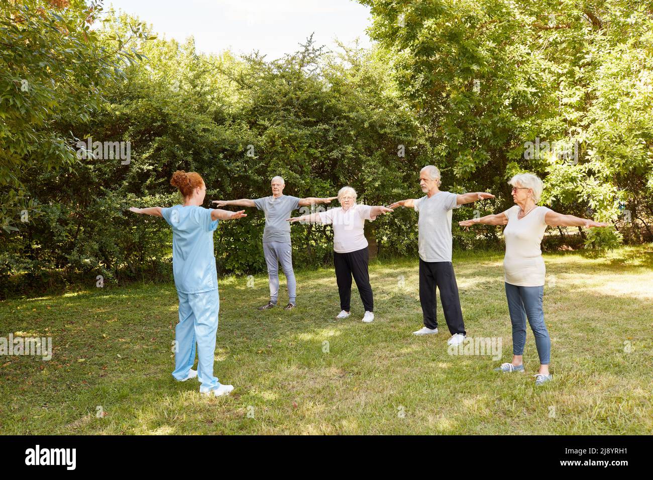 Group of seniors in gymnastics rehab class doing an exercise with ...