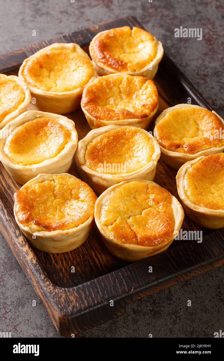 Queijadas Portuguese Cheesecake Tarts close-up on a wooden tray on the ...