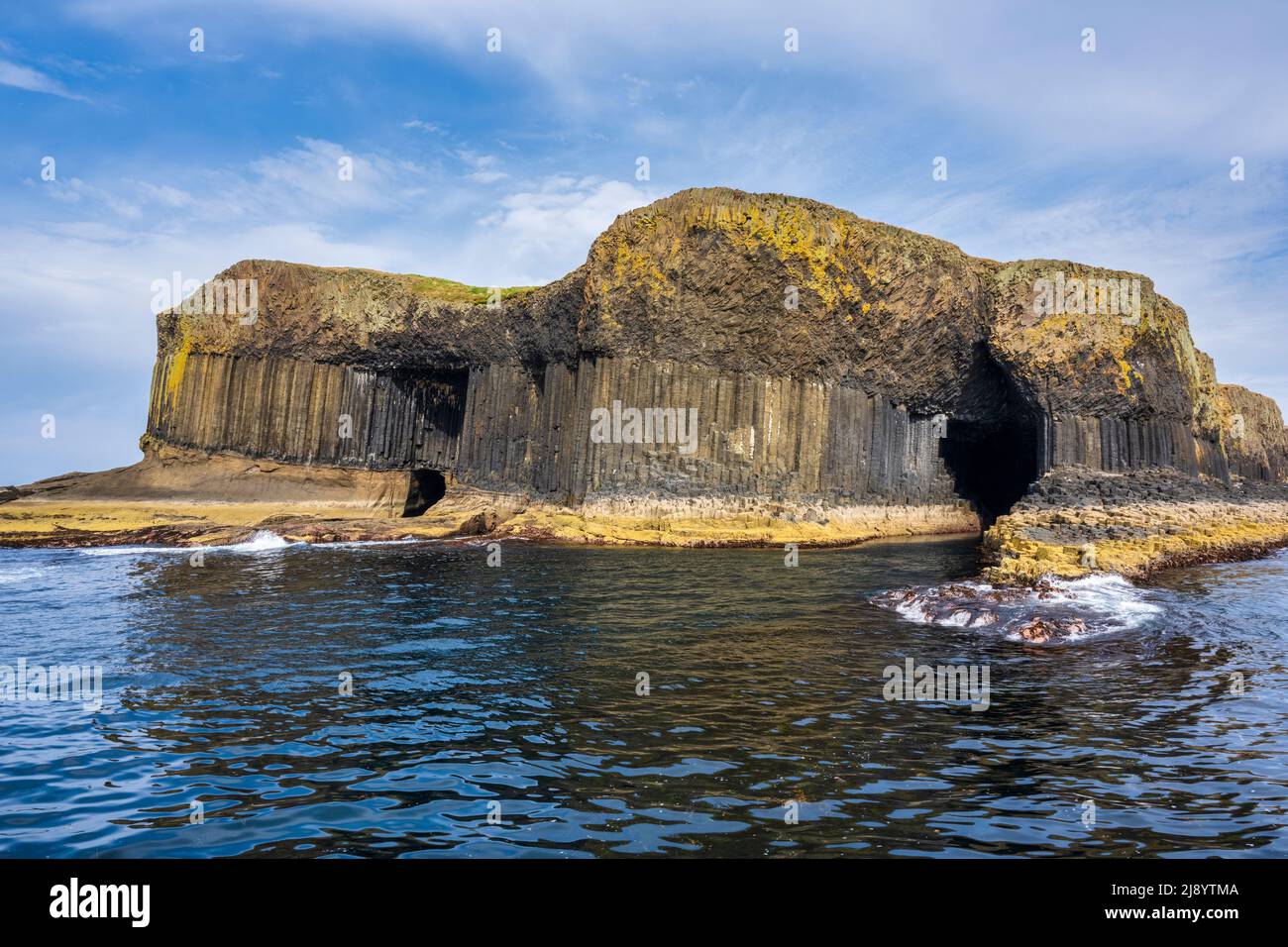 Departing Staffa, view of dramatic sea cliffs with Fingal’s Cave on ...