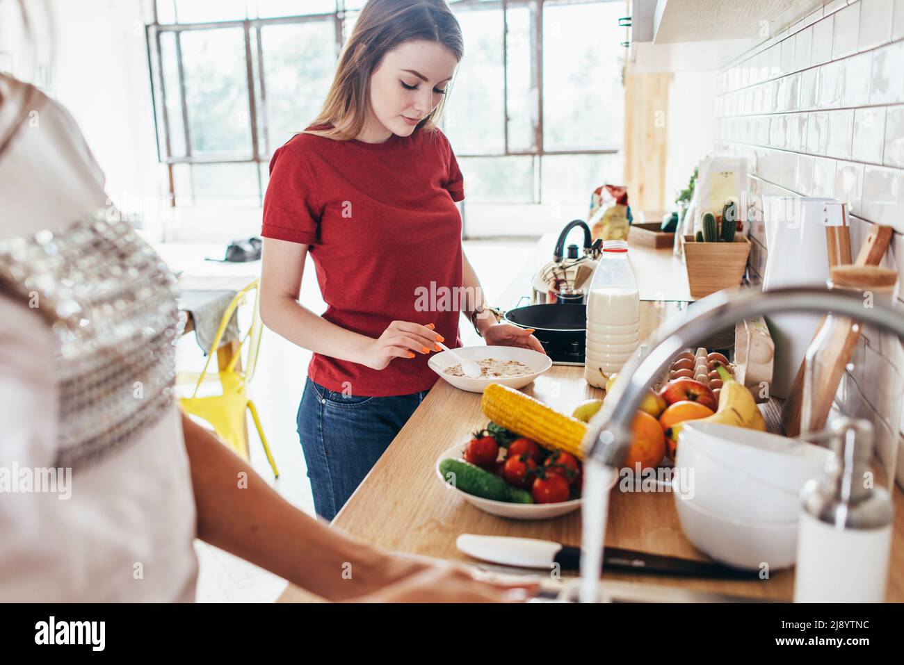 Two women in the kitchen cooking and washing dishes Stock Photo - Alamy