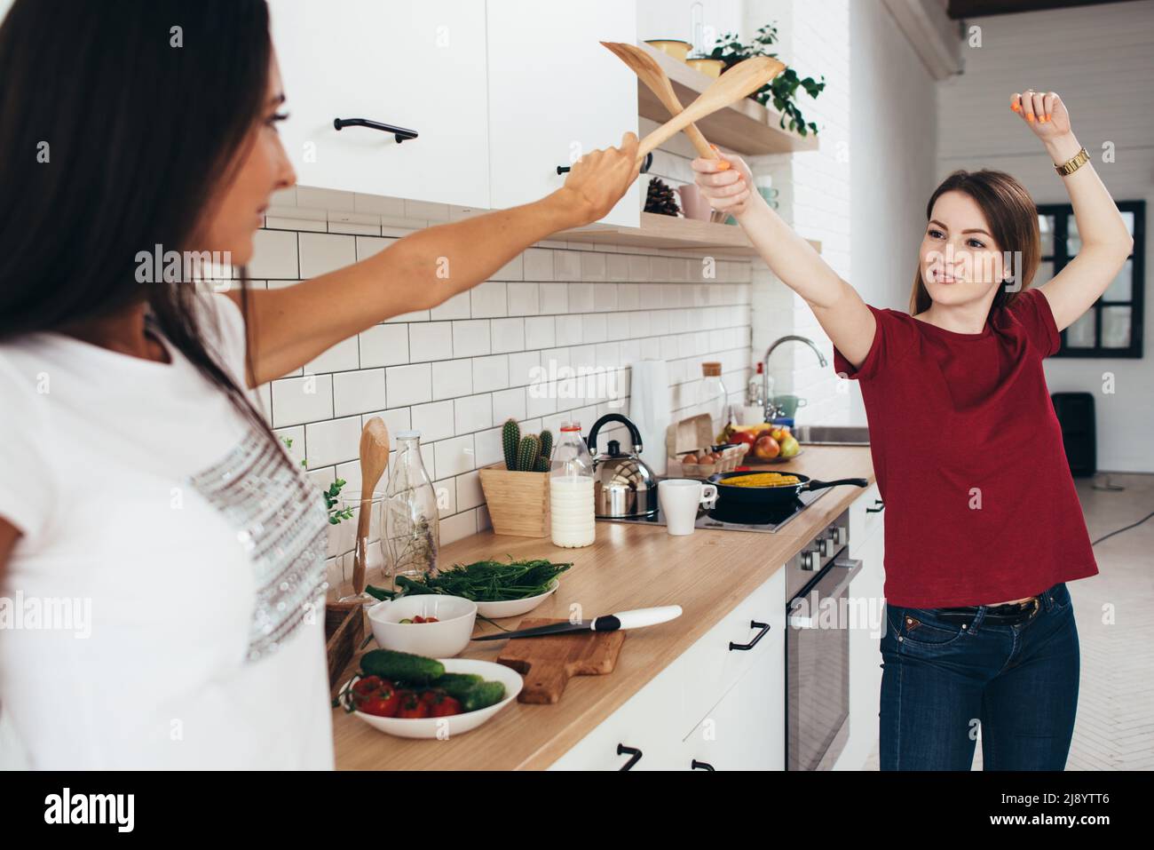 Two woman image that they are fighting on swords by wooden spatulas in ...