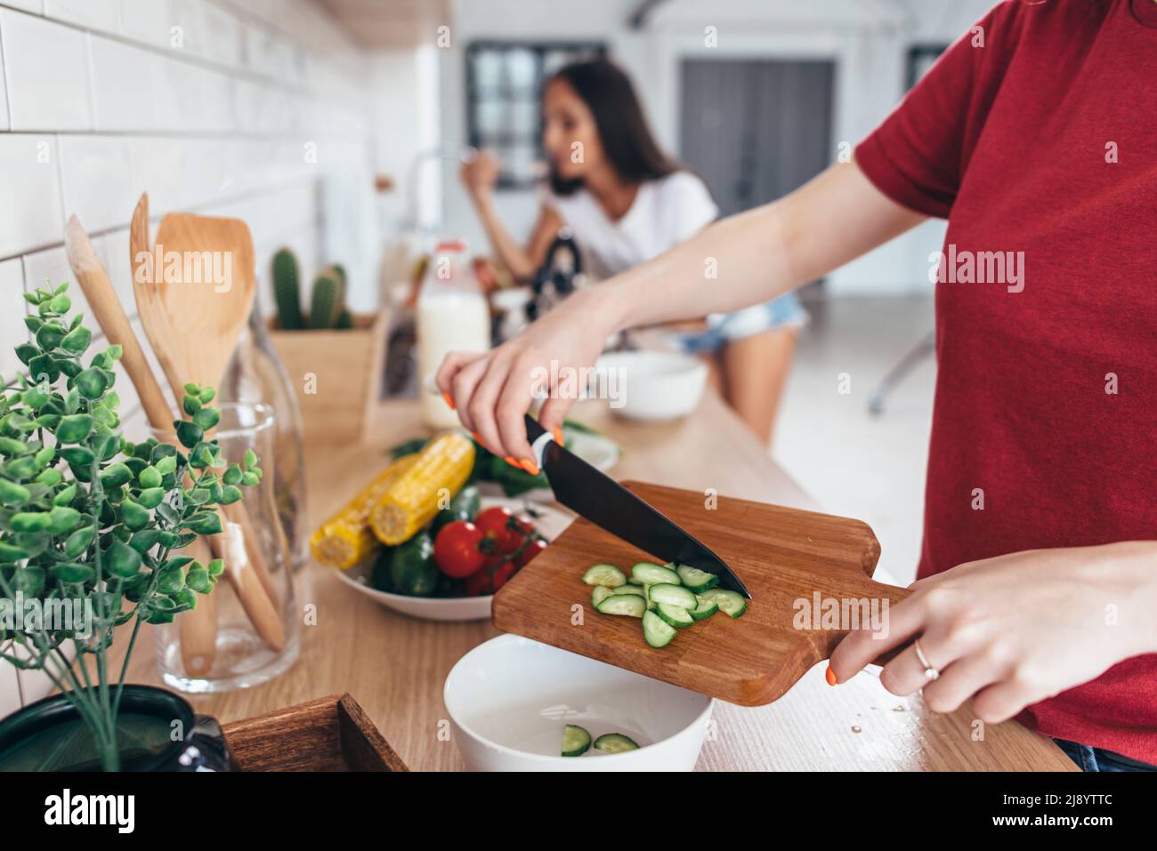 Female hand with knife cutting cucumbers on board Stock Photo - Alamy
