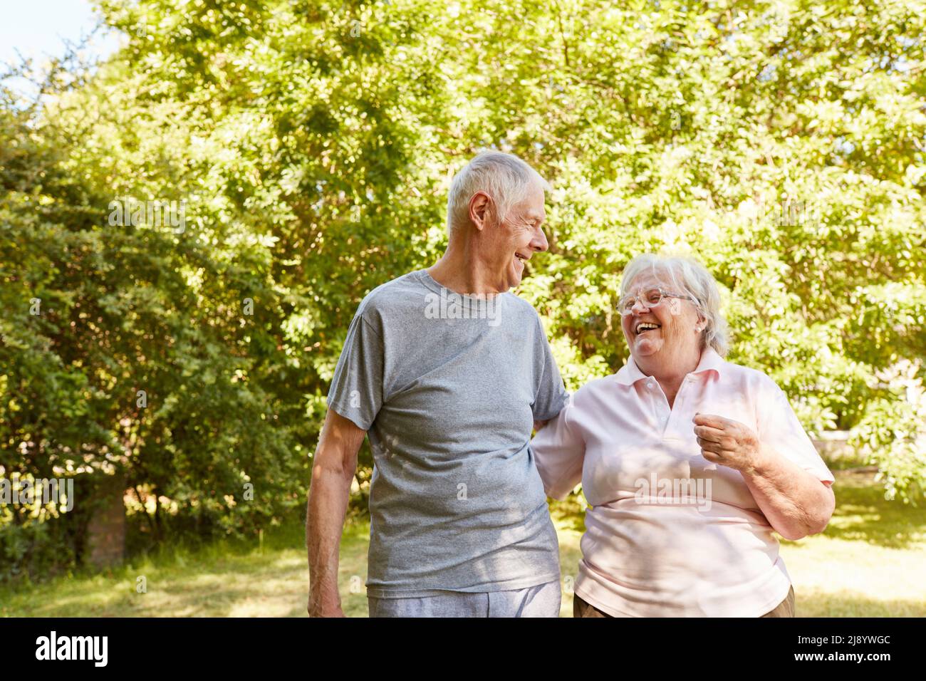 Happy couple of seniors as retired friends on a walk in the park in ...