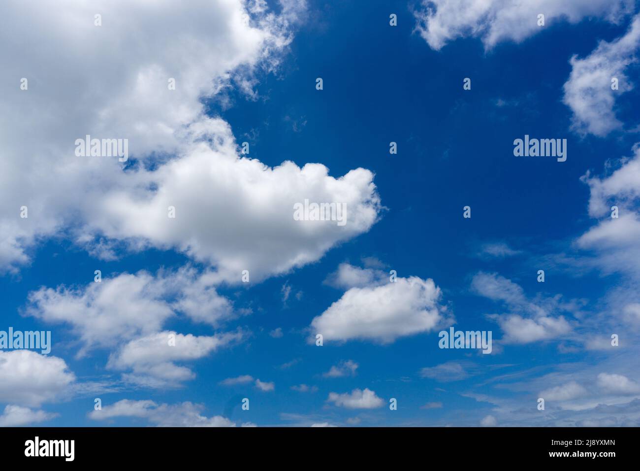 Different shapes of white clouds forming on the blue skies of ...