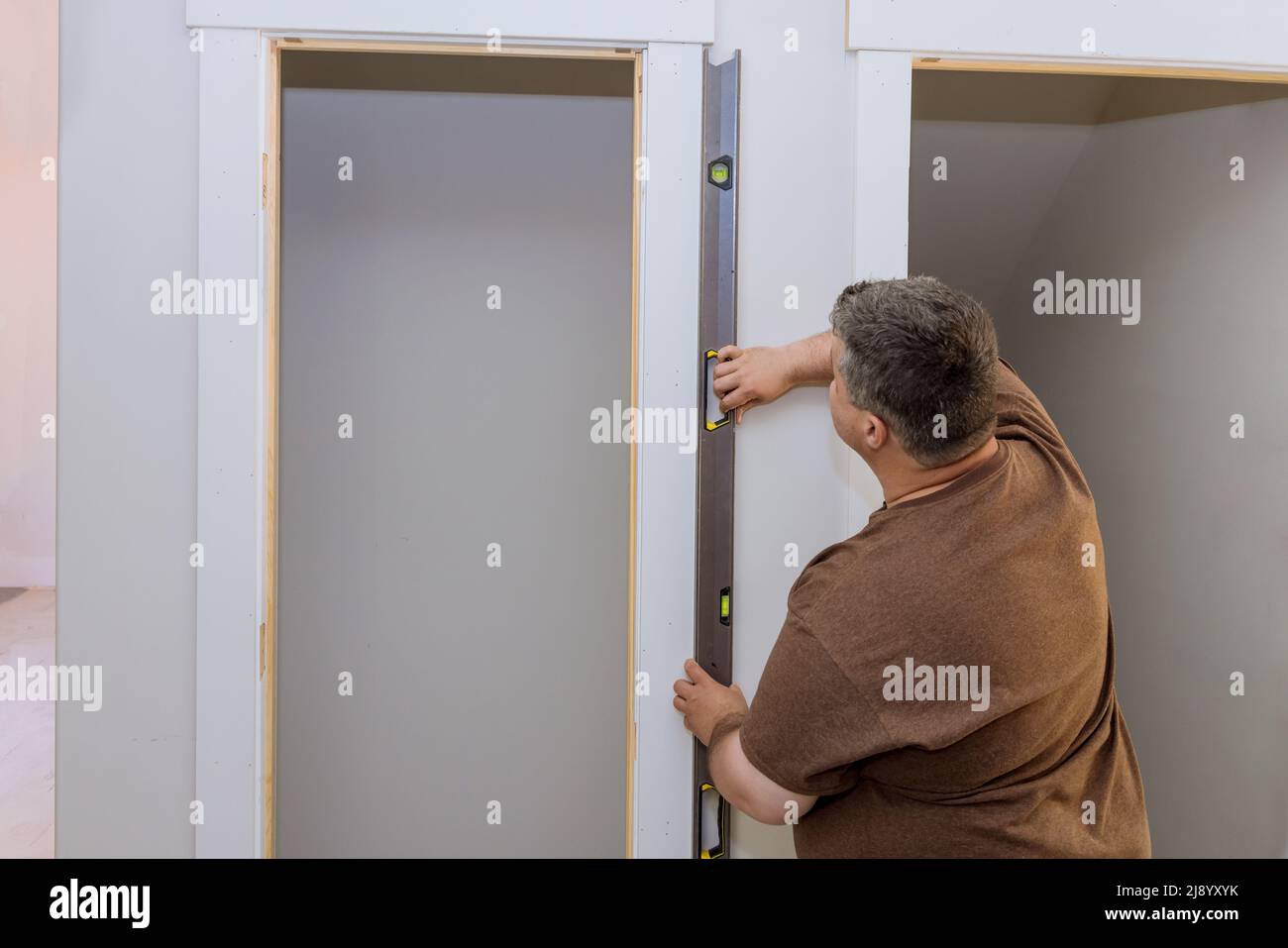 Man is installing the doors with checks level correctness installation ...