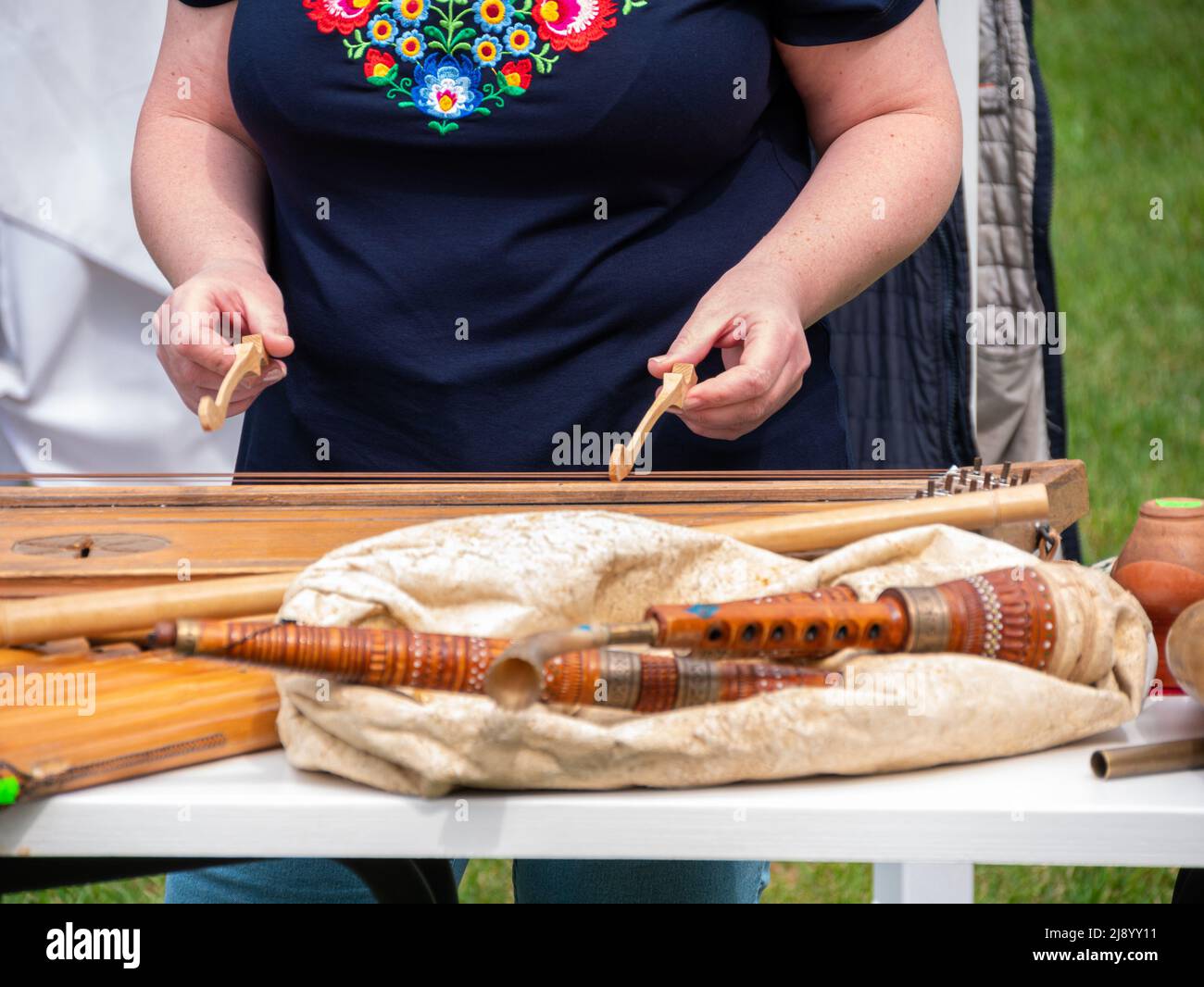 Musician woman plying tsymbaly ethnic musical instrument striking two ...