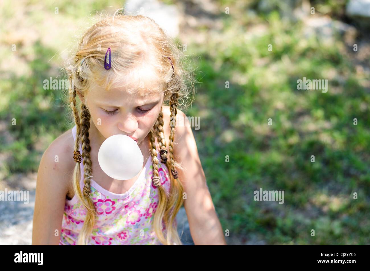 cute girl with blond hair having fun with chewing gum Stock Photo - Alamy