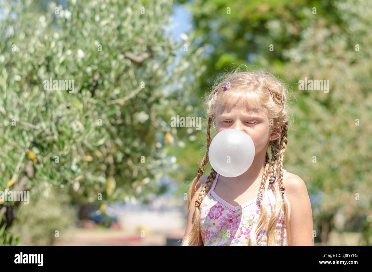 cute girl with blond hair having fun with chewing gum Stock Photo - Alamy