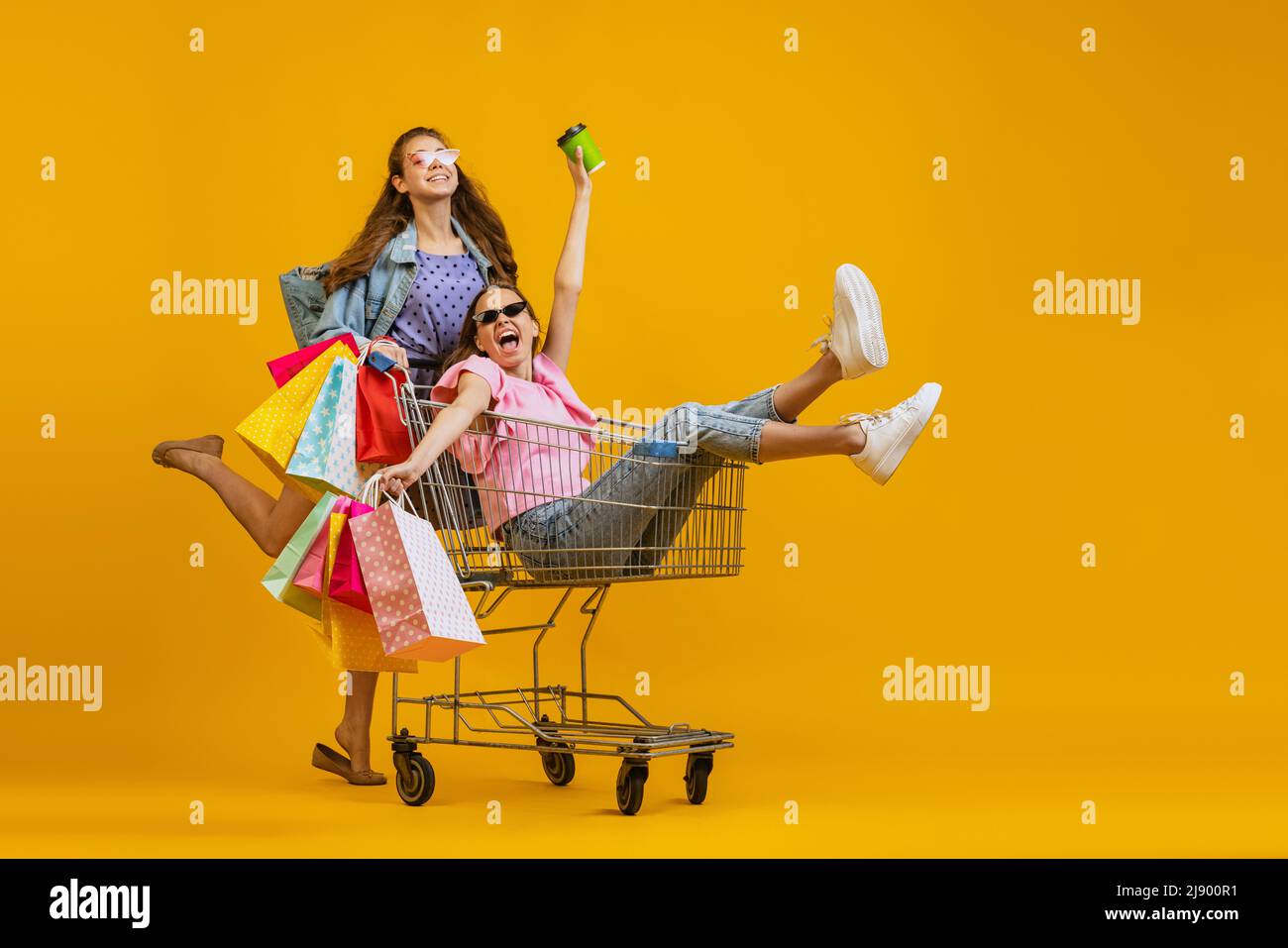 Beautiful young astonished girls go shopping with shopping cart ...