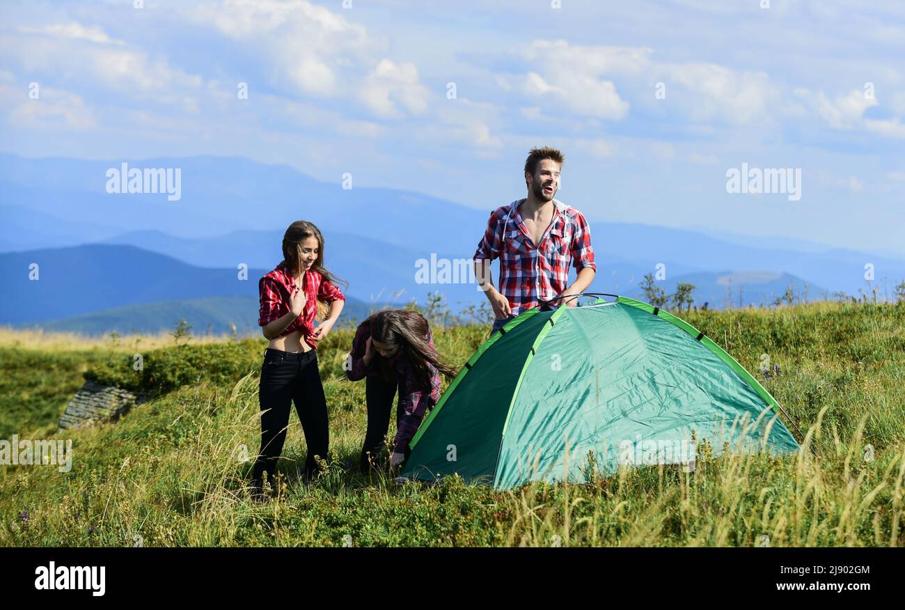 Teamwork concept. Hiking activity. Group friends set up tent on top ...