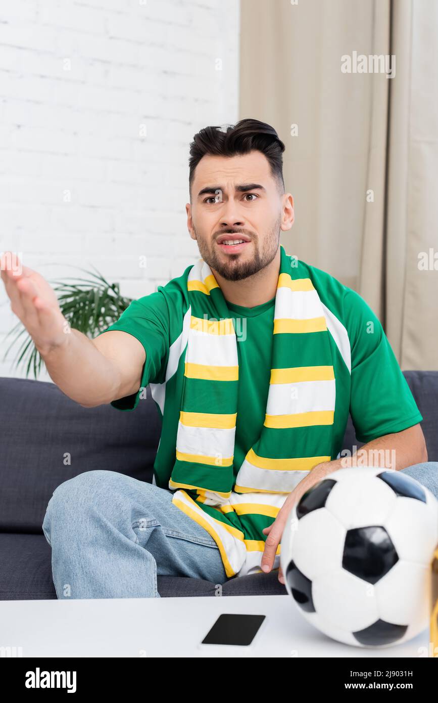 displeased sports fan pointing with hand while watching football match ...