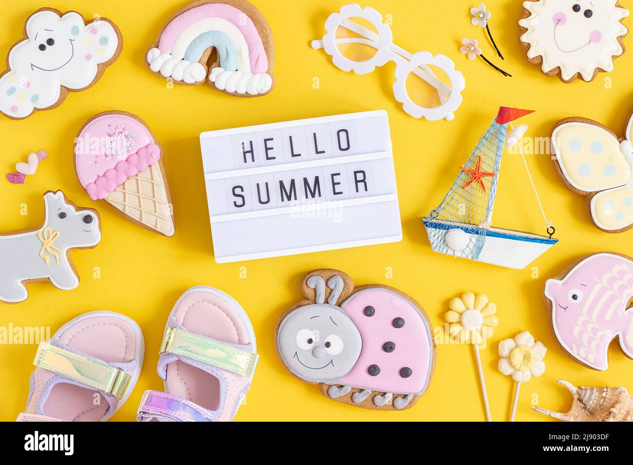 Hello summer text on lightbox and cute summer symbols on yellow ...