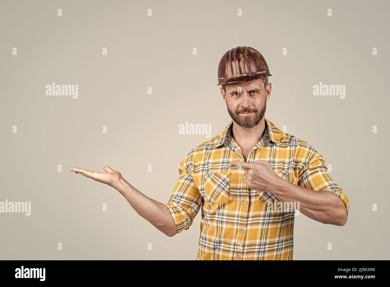 handsome man foreman in construction safety helmet and checkered shirt ...
