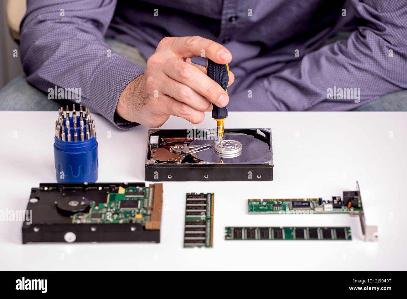 The master repairs the disassembled hard disk on the desktop next to ...