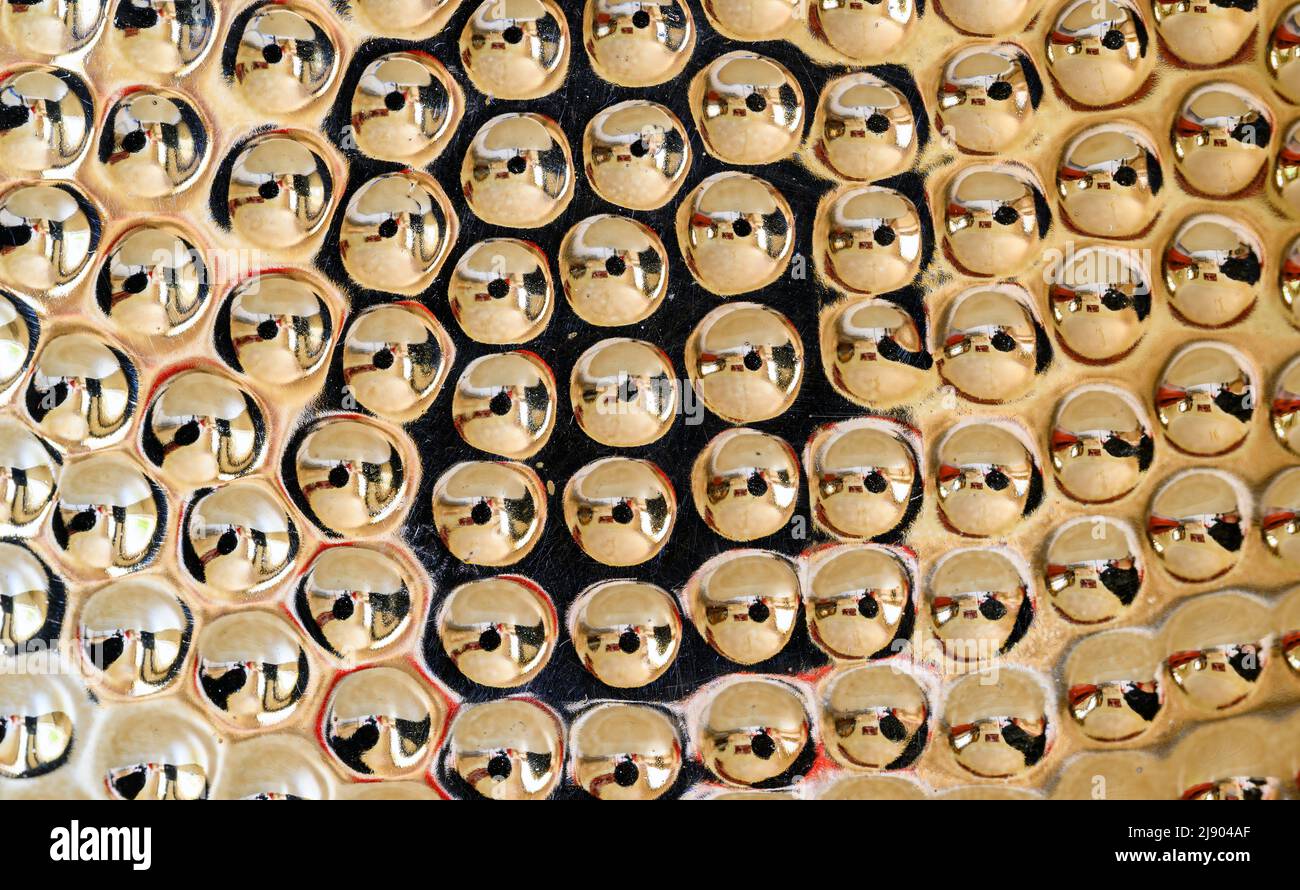 Detail of circular dimples on a lamp base. The gold metal surface ...