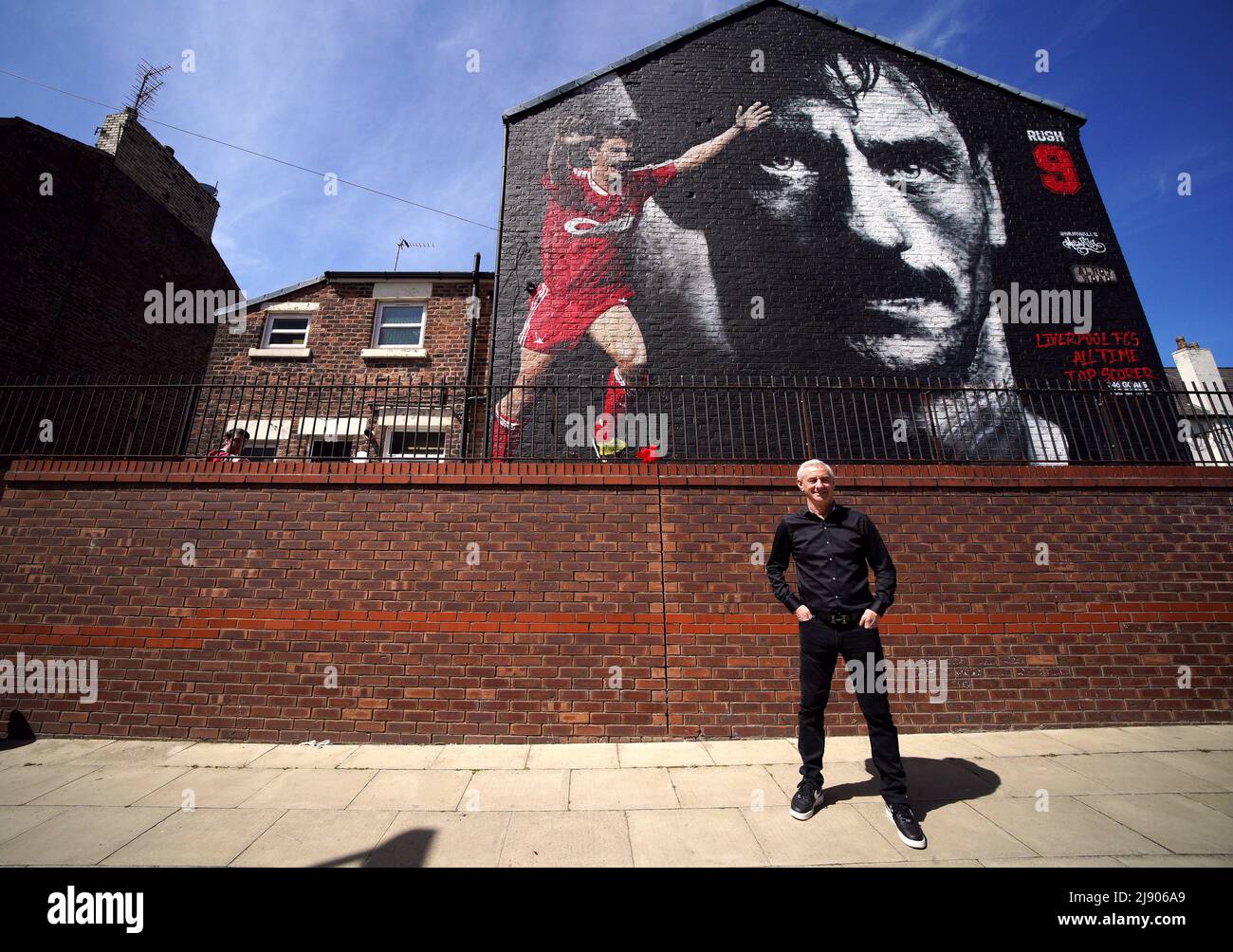 Former Liverpool player Ian Rush poses in front of a mural of himself ...
