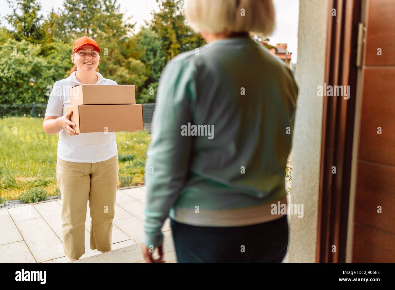 postman mail carrier carry two paper post boxes deliver to customer in ...