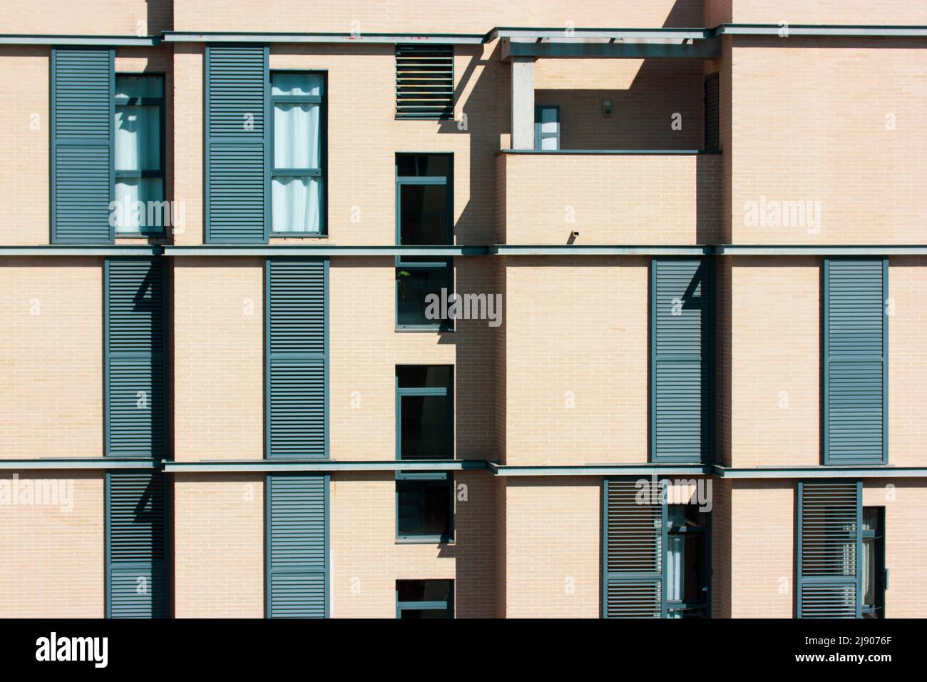 Facade of residential high-rise modern beige building, windows with ...