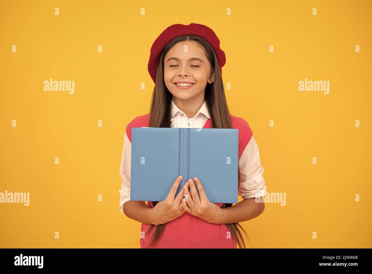 dreamy teen school girl in french beret reading book on yellow ...