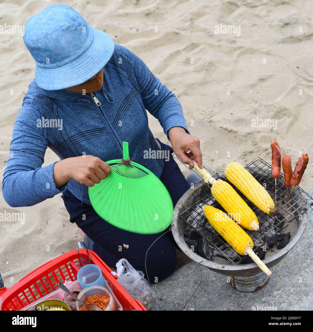 Nha Trang, Vietnam - 17 May 2022: Vietnamese woman cooks grilled maize ...
