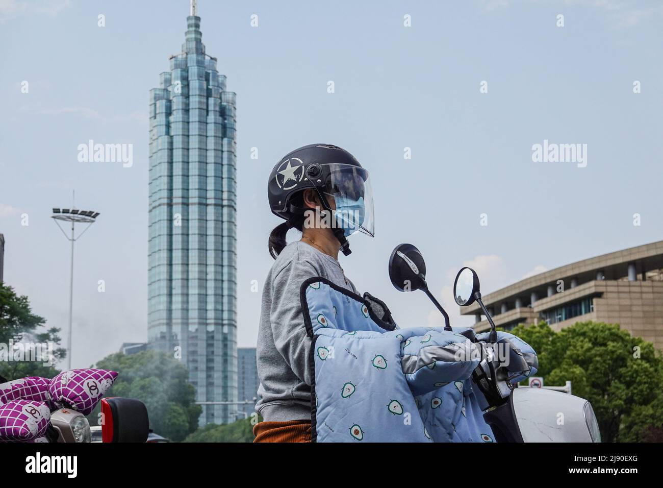 Changzhou, China. 17th May, 2022. A woman wearing a facemask rides an ...