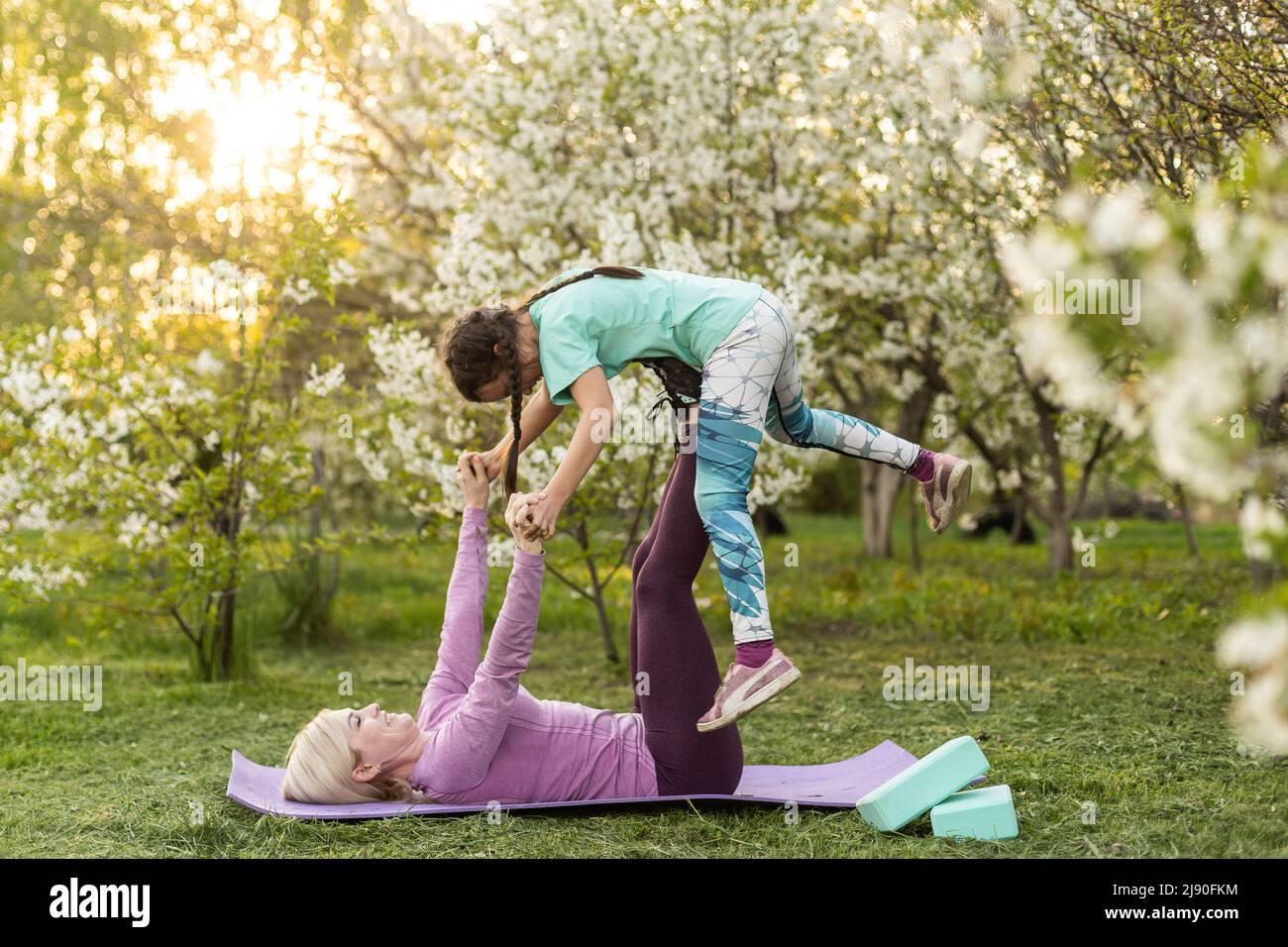 Mother and her daughter outdoors doing yoga, healthy lifestyle Stock ...