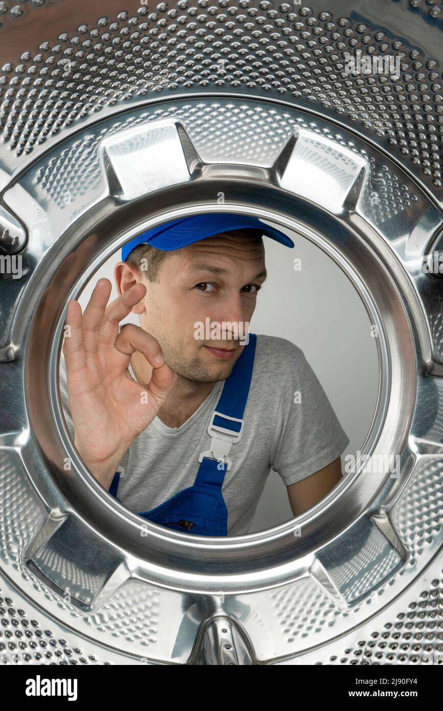 Male repairman in uniform shows a OK sign with his hand, a photo from ...