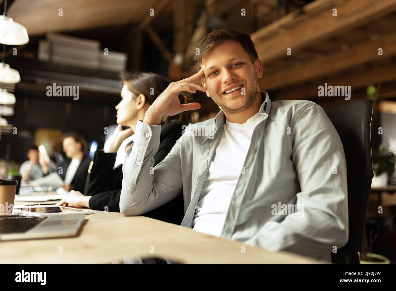 Senior developer. Happy man looking at camera and smilling. Work in modern loft style office ...