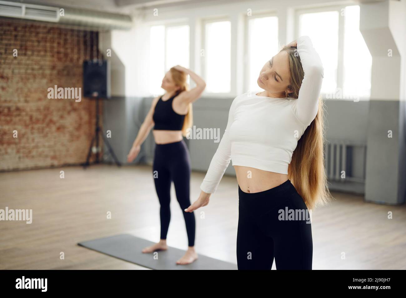 Group of people stretching at yoga class in fitness studio, woman ...