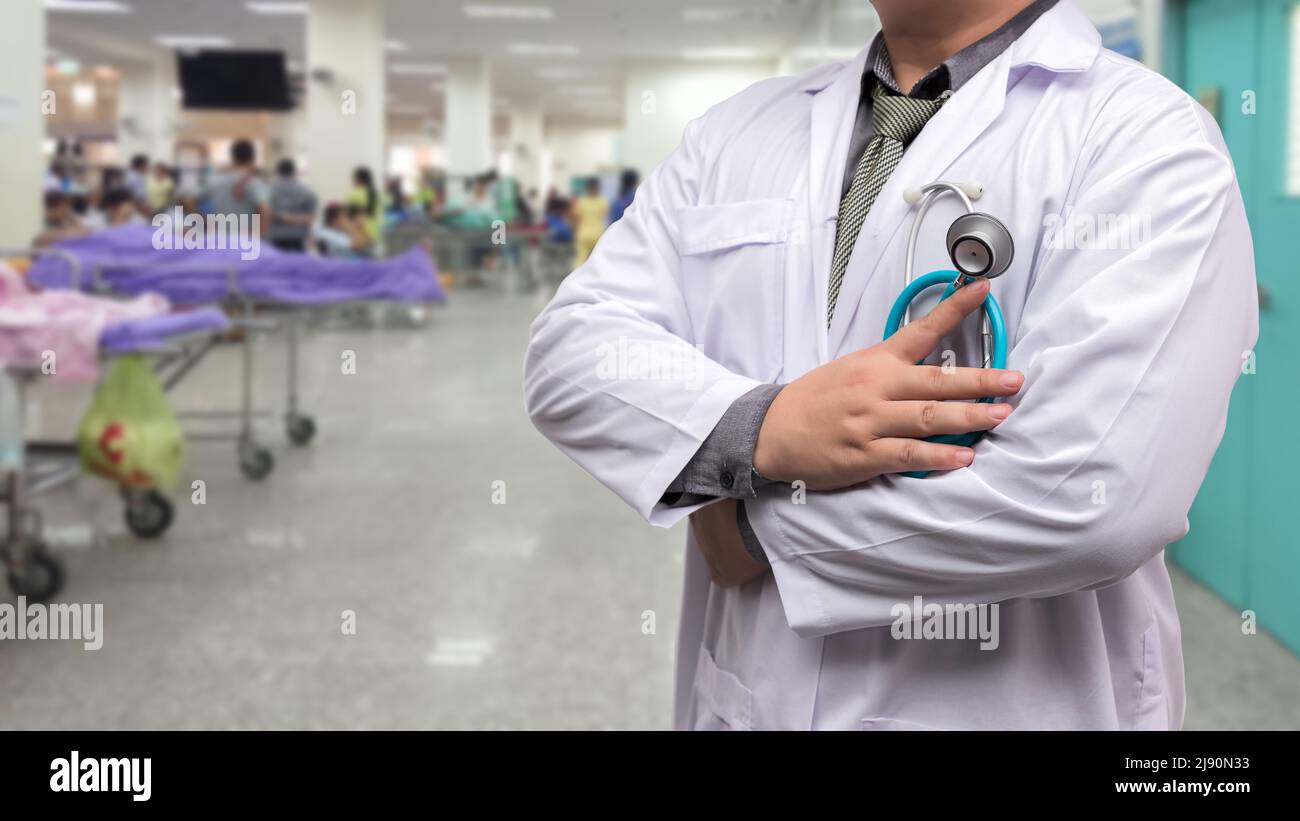 Doctor in gown uniform with stethoscope standing and fold his arms over ...