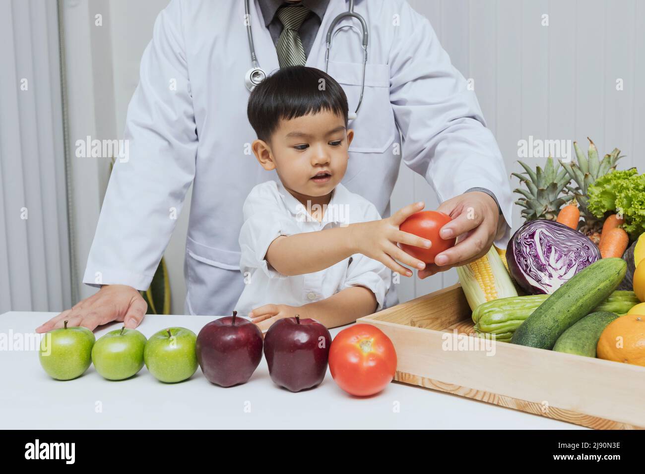 A boy and doctor happy to have healthy food. Kid learning about ...