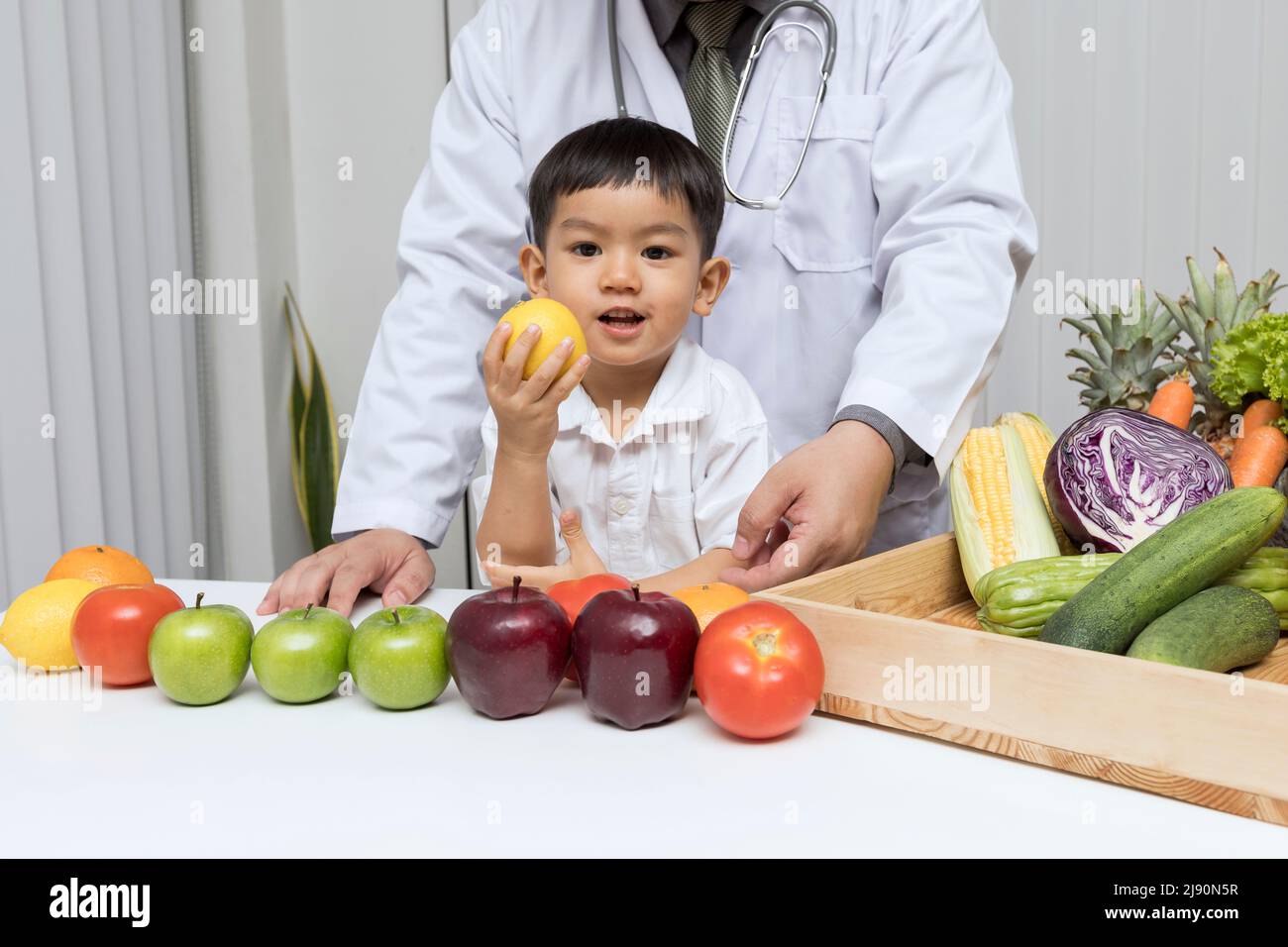 A boy and doctor happy to have healthy food. Kid learning about ...