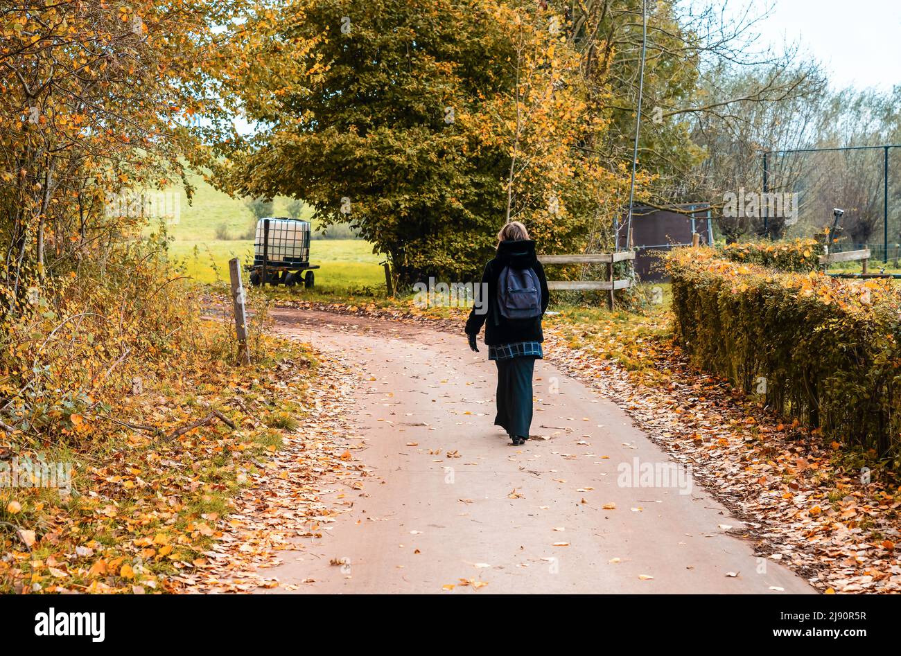 Attractive thirty year old woman in a black furry coat walking away on ...