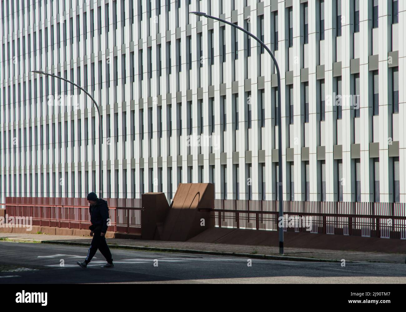 A lonely man crosses the street early Sunday morning, in the shadow of ...