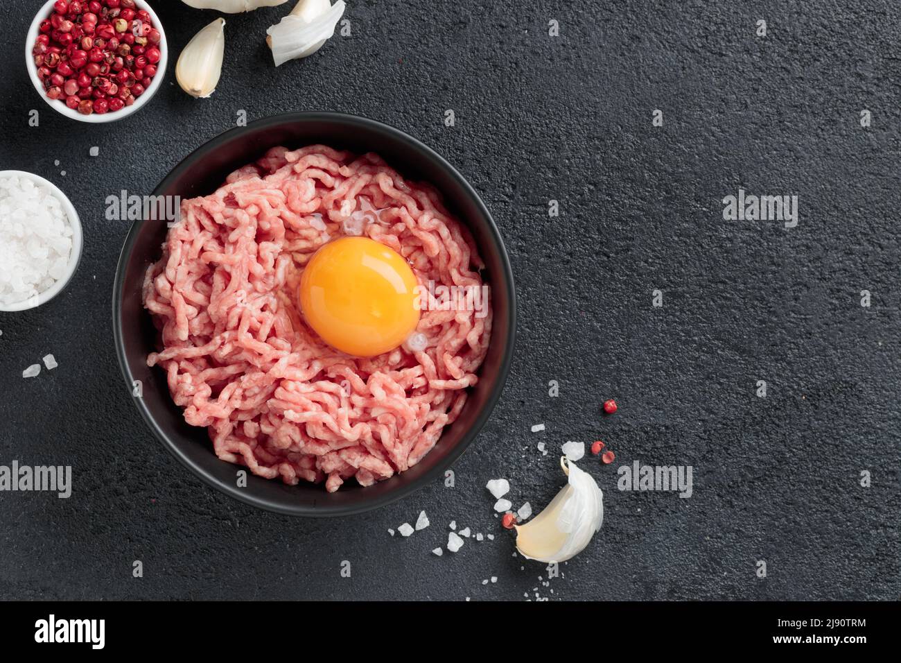 Cutlet ingredients beef farce meat with egg in a plate on black ...
