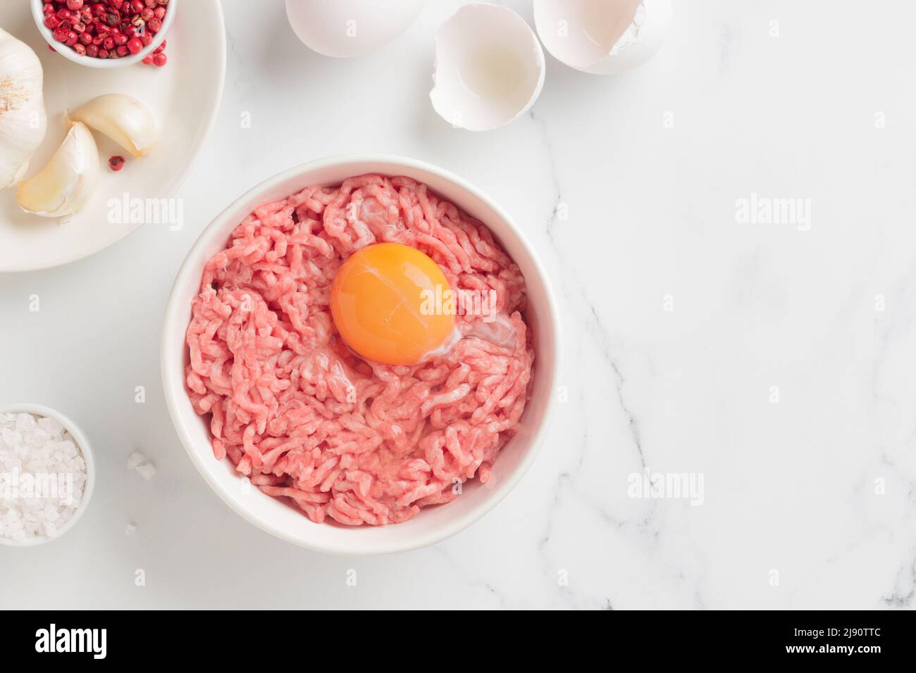 Cutlet ingredients beef farce meat with egg in a plate on white ...