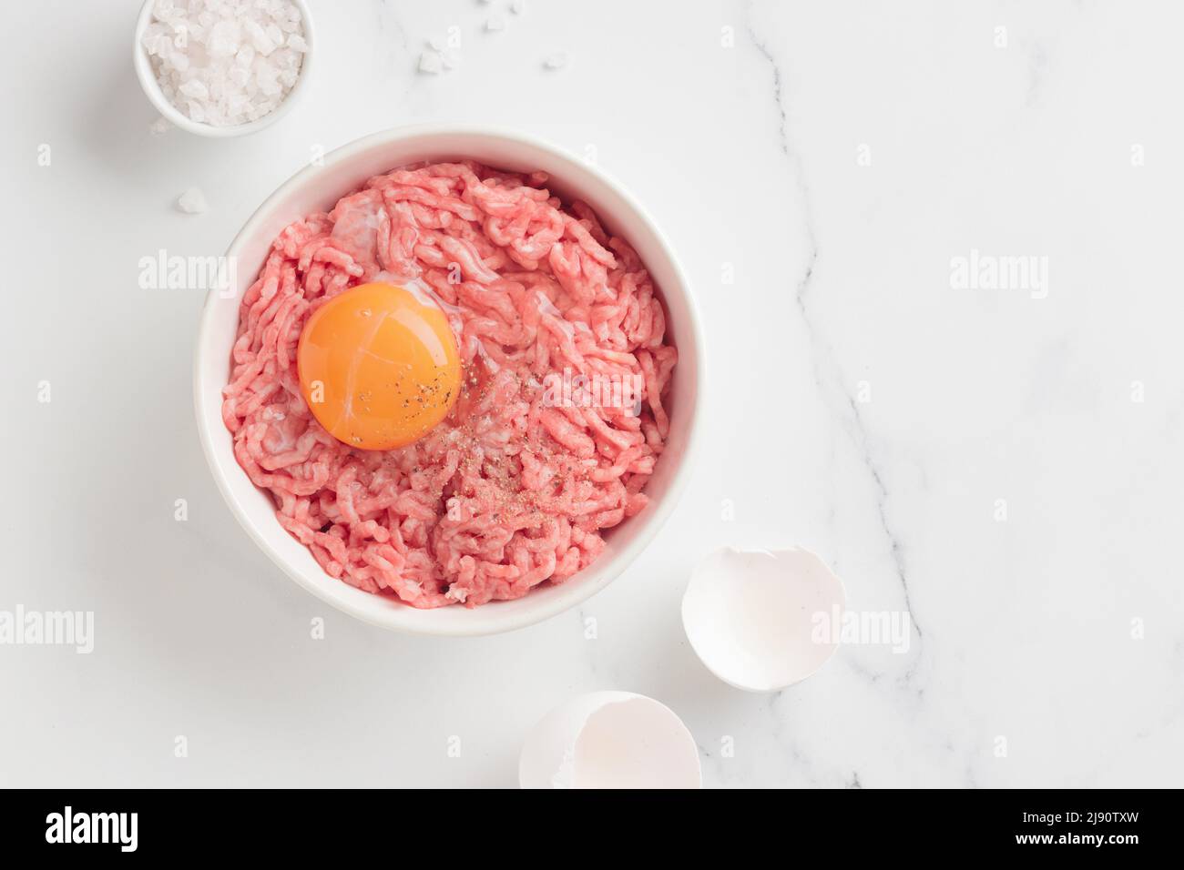 Cutlet ingredients beef farce meat with egg in a plate on white ...