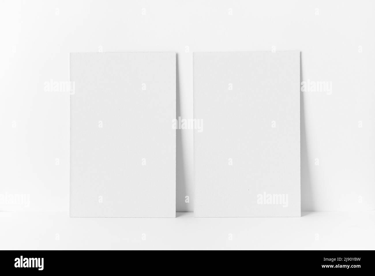 Two empty white vertical sheets on a white table Stock Photo - Alamy