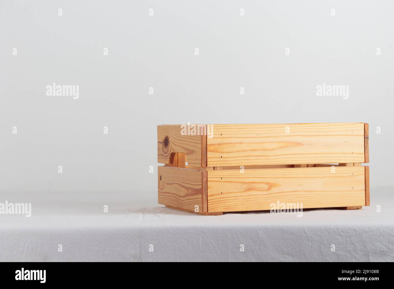Empty wooden box on a table near white wall Stock Photo - Alamy