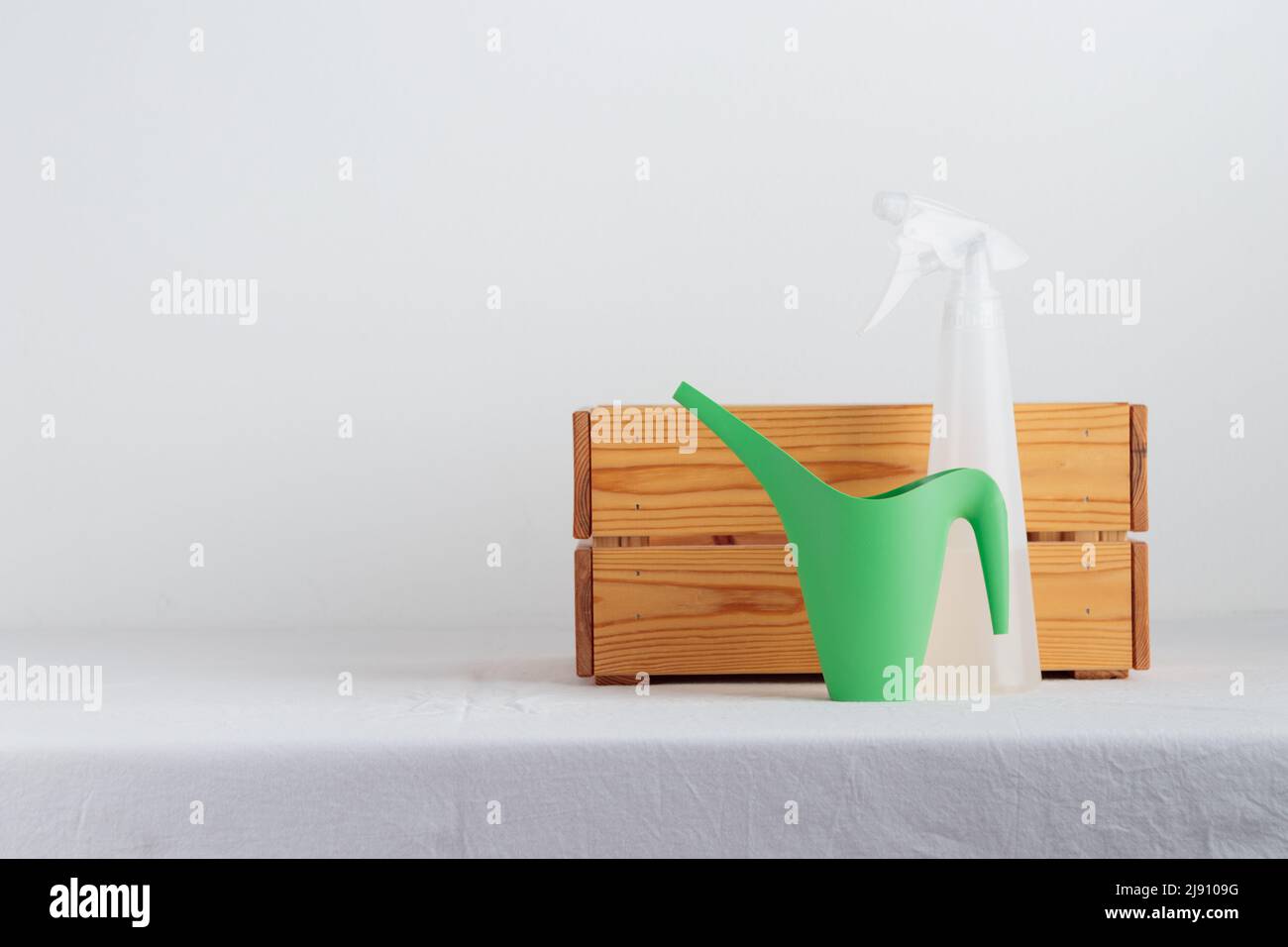 Watering can and spray gun with the wooden box on a table Stock Photo ...
