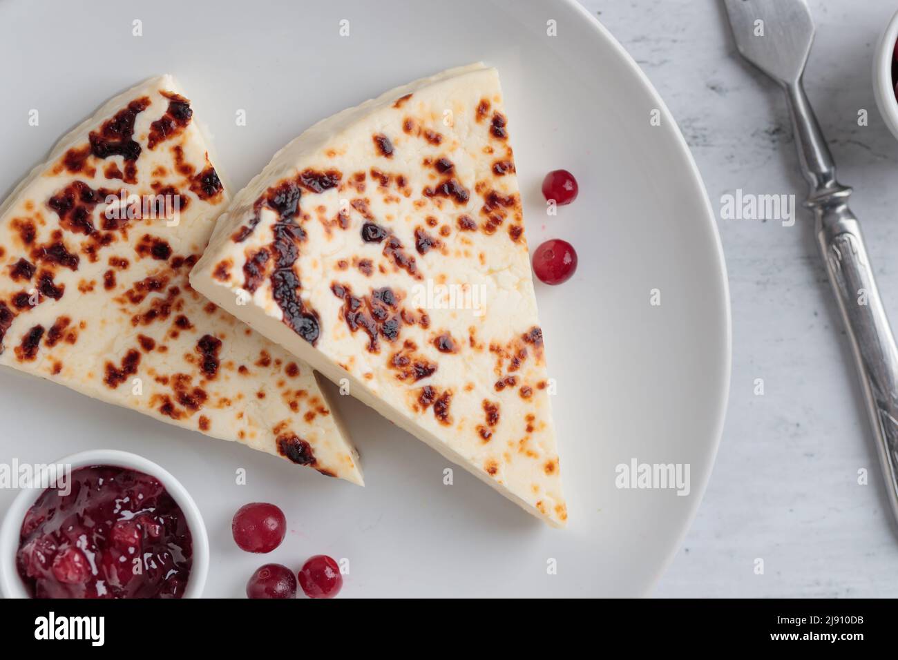Leipajuusto - traditional Finnish baked cheese - with red berries in a ...