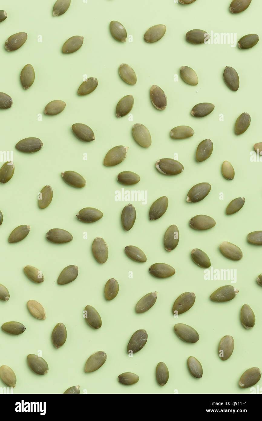 Pumpkin seeds pattern on a green background Stock Photo - Alamy