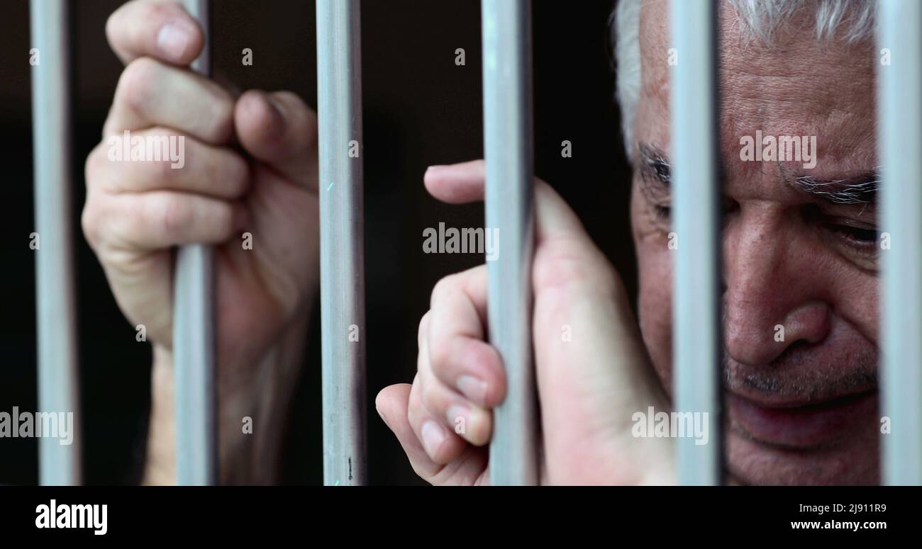 Depressed middle aged man feeling trapped behind bars Stock Photo - Alamy