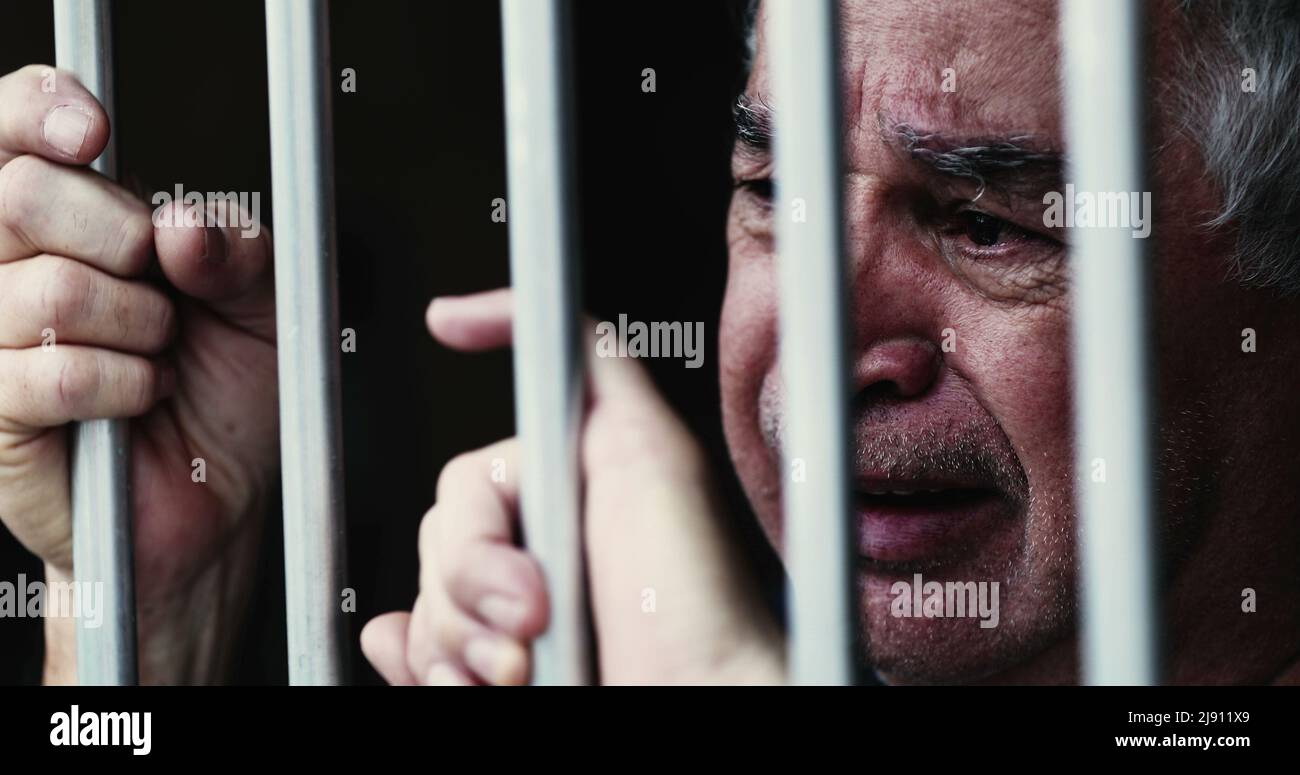 Desperate old man behind bars. Imprisoned person Stock Photo - Alamy