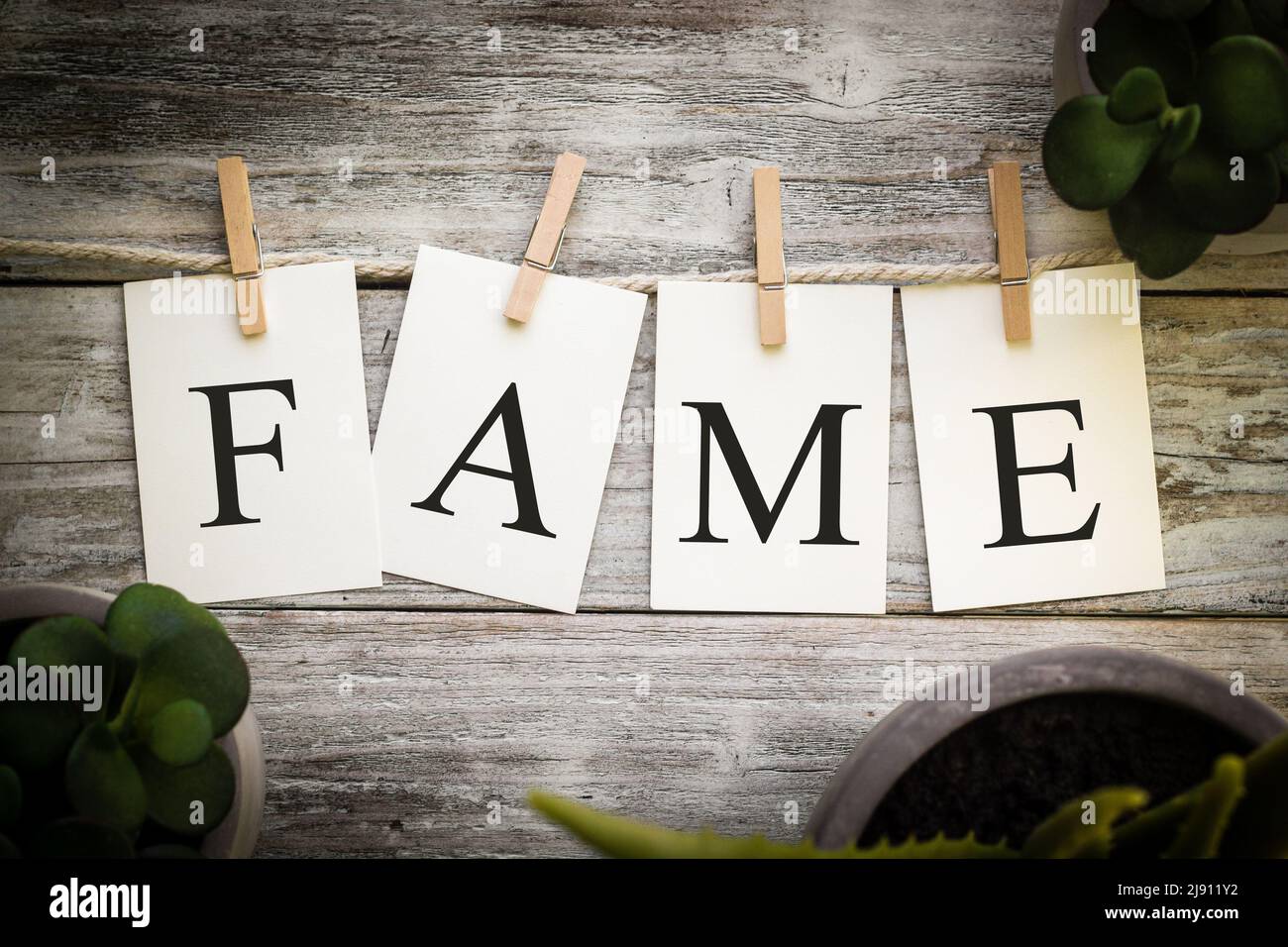 A set of printed cards spelling the word FAME on an aged wooden ...