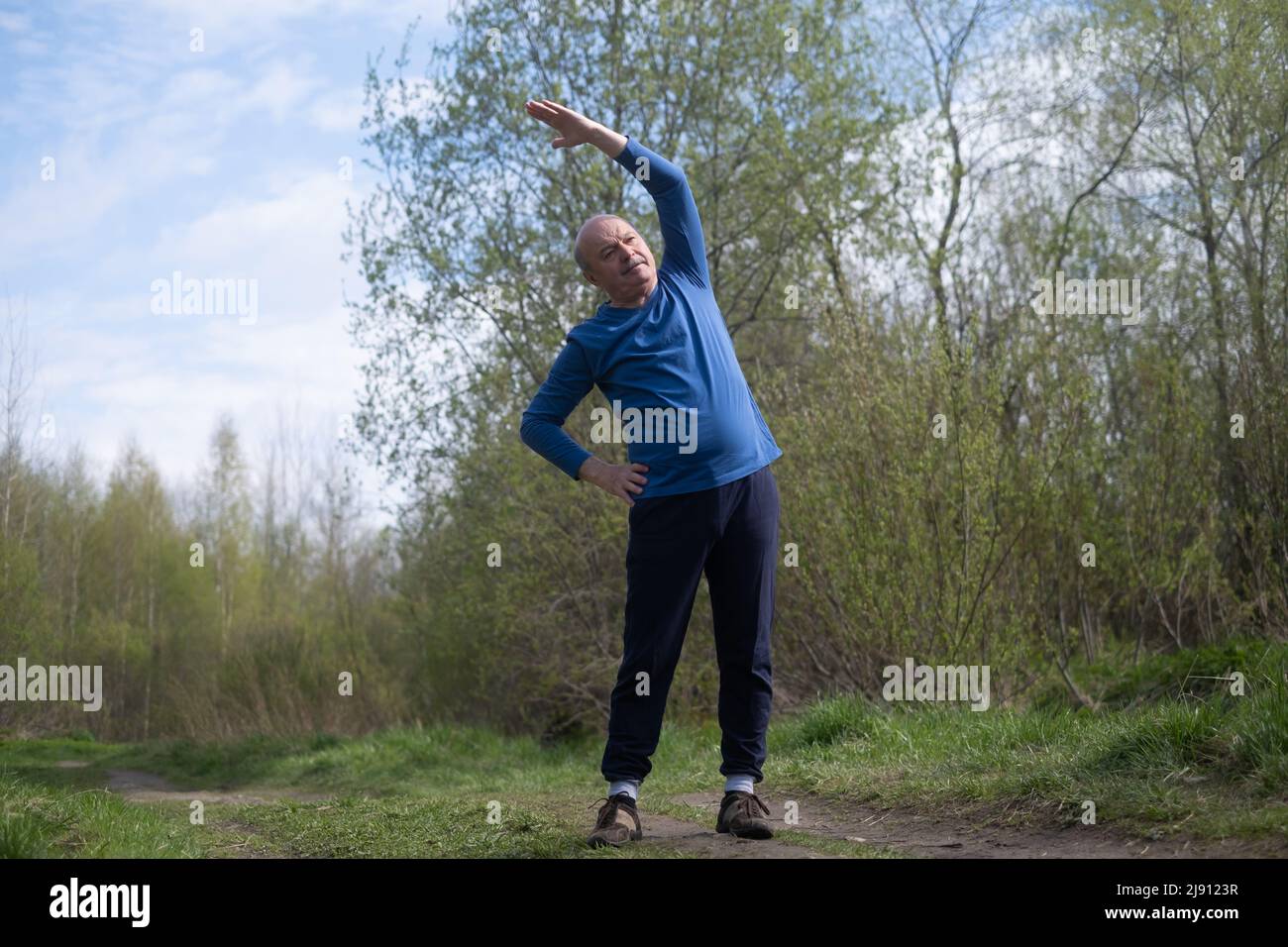 Senior runner with armband doing stretching. Spring nature. Healthy ...