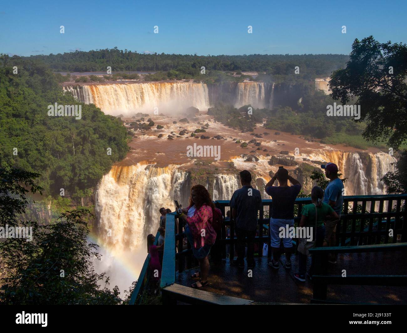 Tourists admiring the Iguazu Falls, one of the biggest falls in the ...