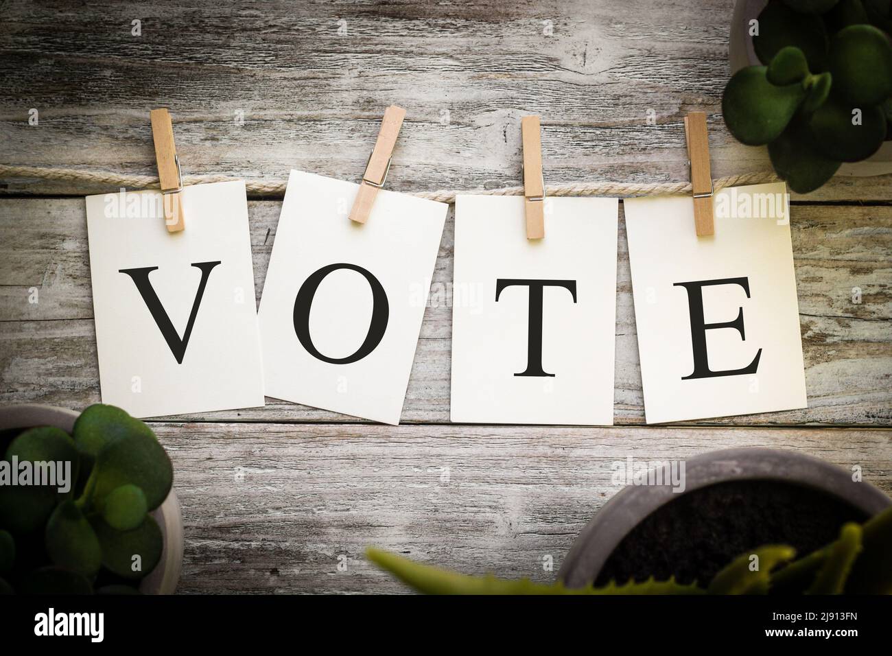 A set of printed cards spelling the word VOTE on an aged wooden ...